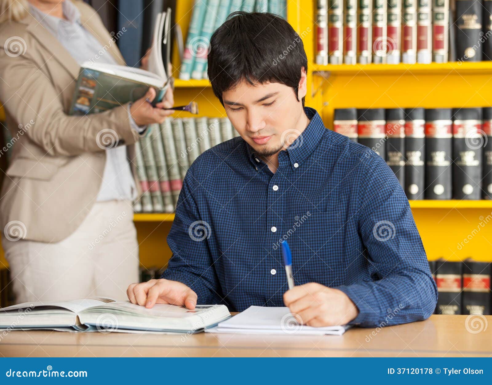 Student Writing in Book Bij Universiteitsbibliotheek Stock Foto - Image ...