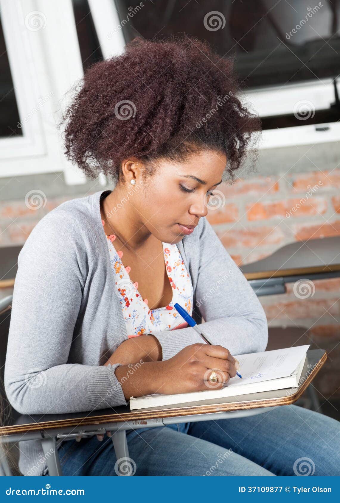 Student Writing Exam at Desk in Classroom Stock Image - Image of ...