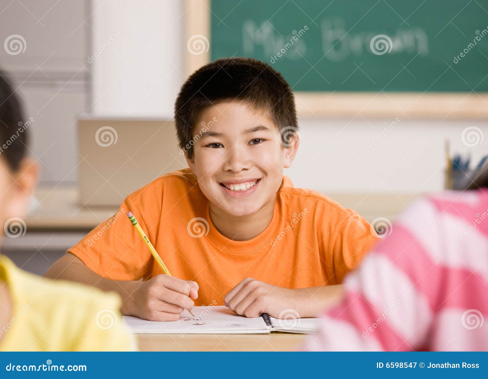 Student Writing In Notebook In School Classroom Royalty Free Stock ...