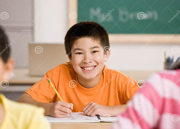Student Writing in Notebook in School Classroom Stock Image - Image of ...
