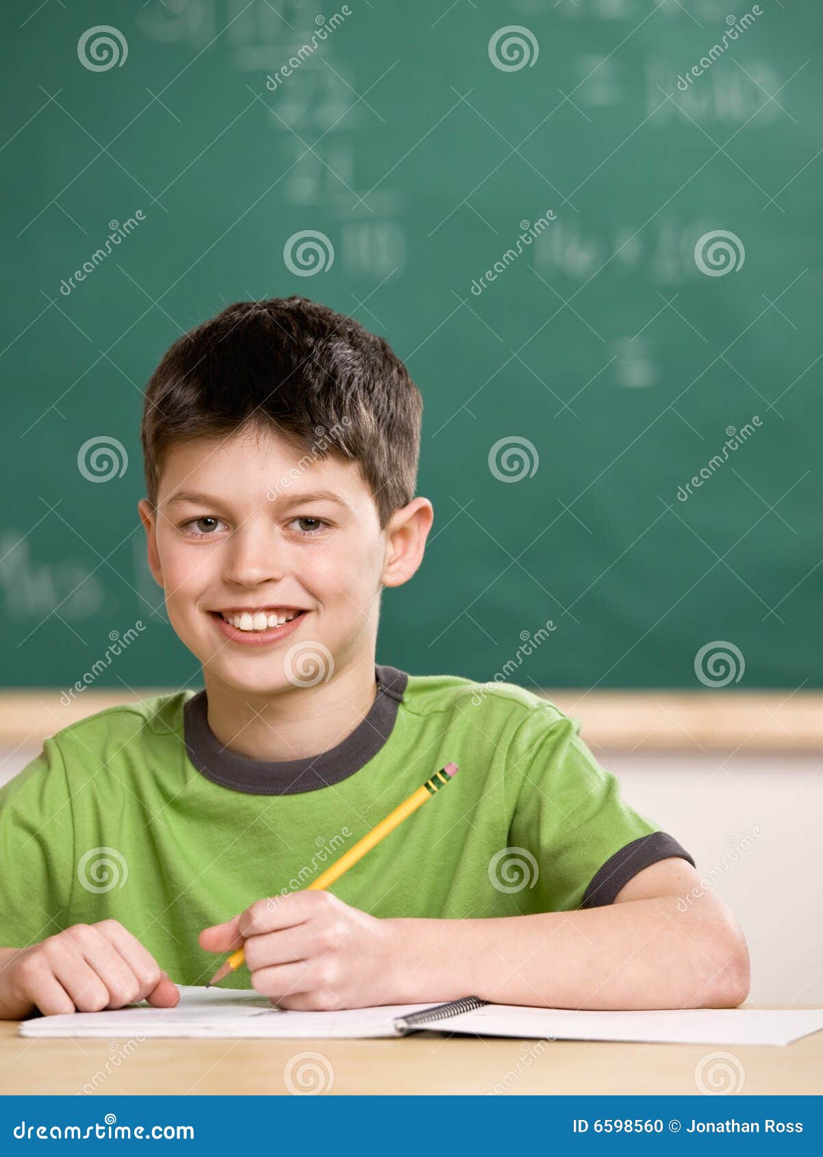 Student Writing in Notebook in School Classroom Stock Photo - Image of ...