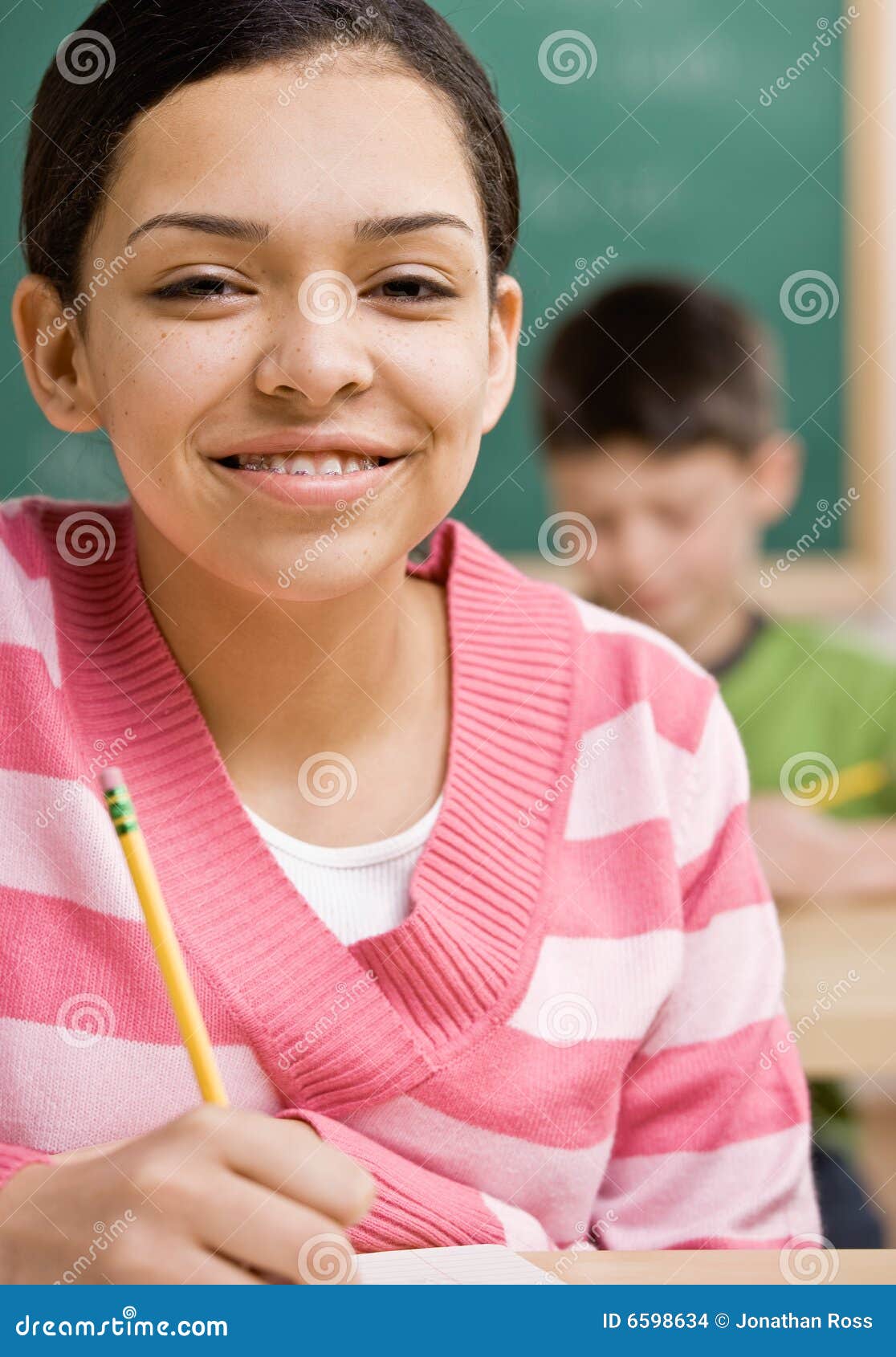 Student Writing in Notebook in School Classroom Stock Photo - Image of ...