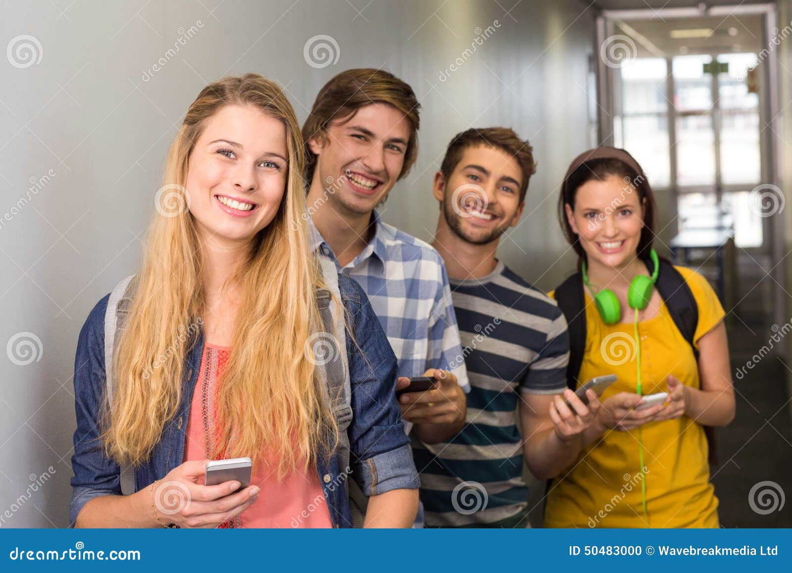 Students with Cellphones at College Corridor Stock Photo - Image of ...