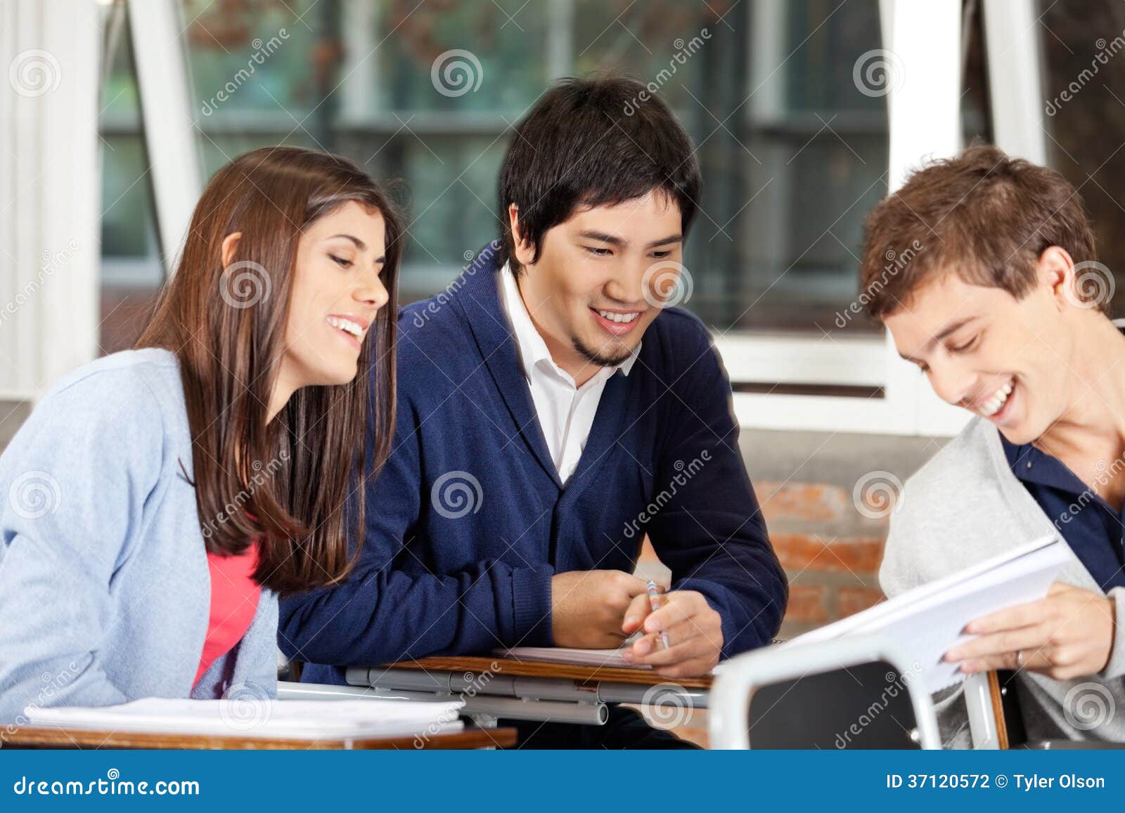 Students Discussing Over Book in Classroom Stock Photo - Image of ...