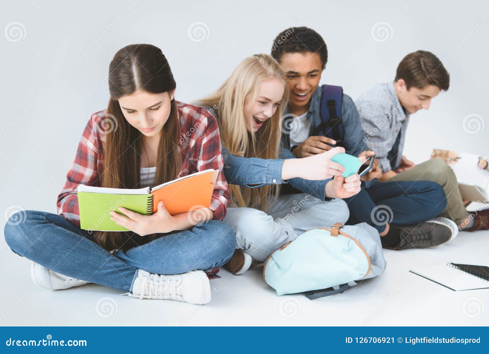 Students Doing Homework while Multiethnic Friends Using Smartphones ...