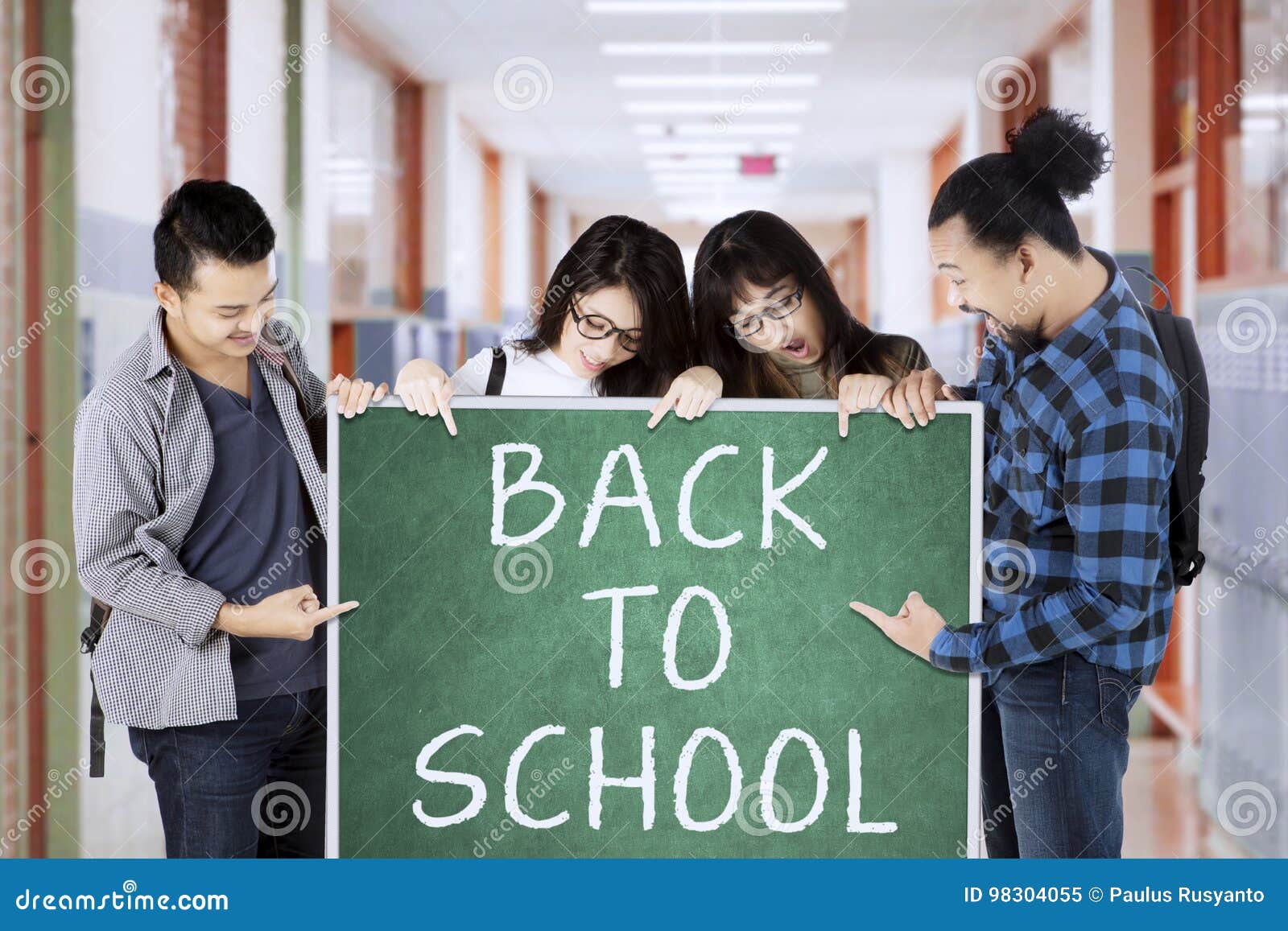 Students Hold Back To School Text in Corridor Stock Image - Image of ...