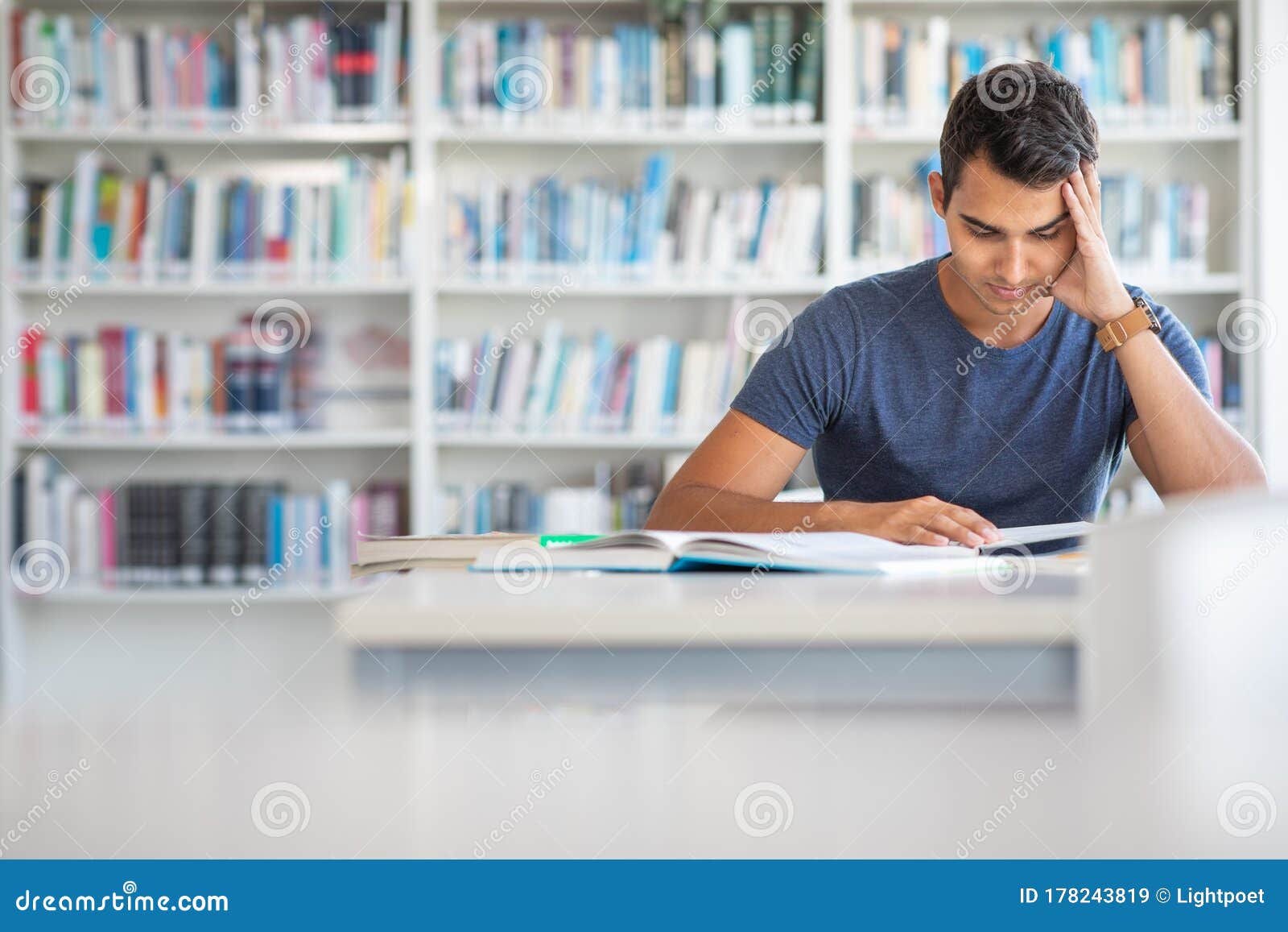 Students in a Library - Handsome Student Reading a Book Stock Image ...