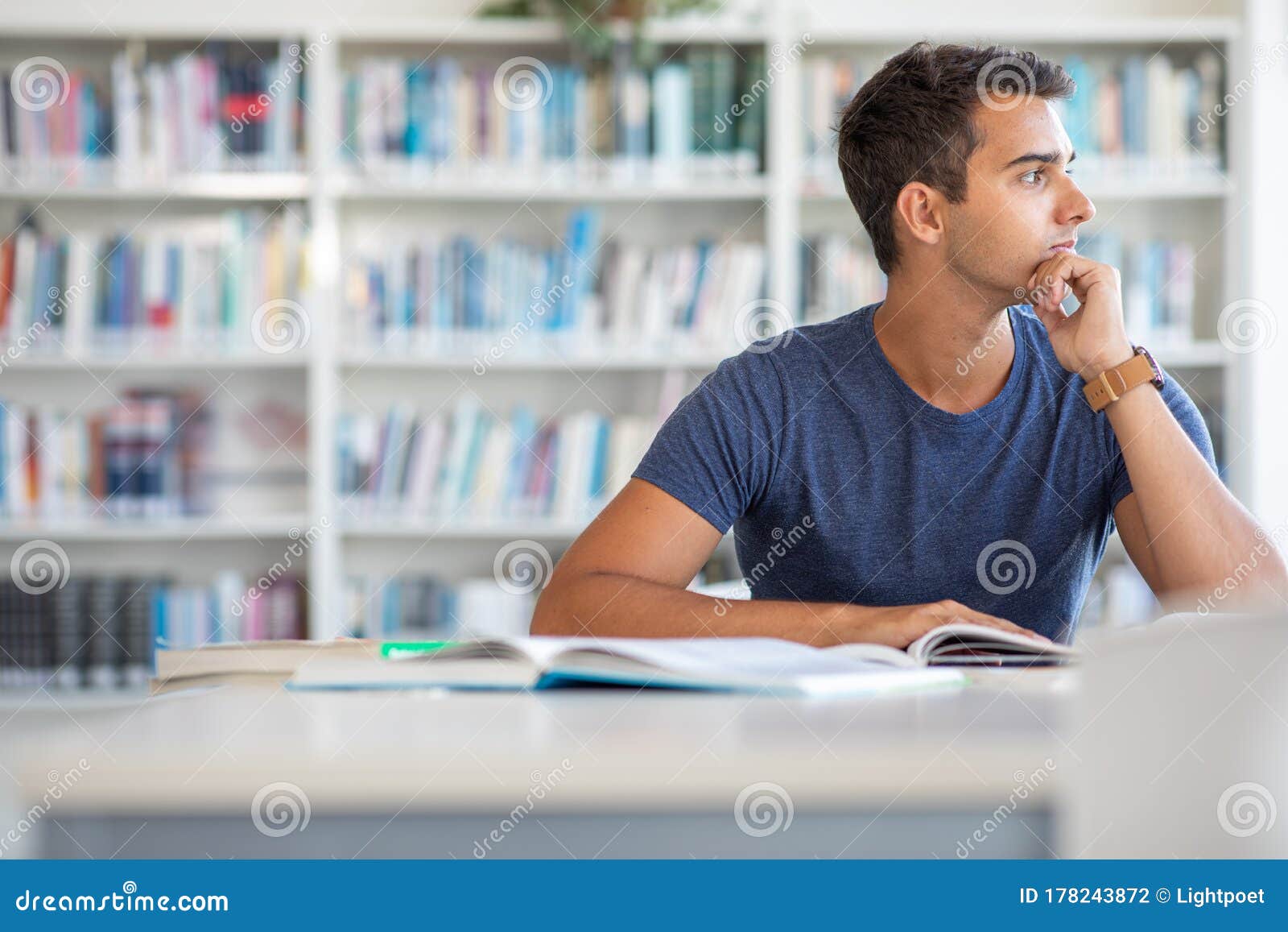 Students in a Library - Handsome Student Reading a Book Stock Photo ...