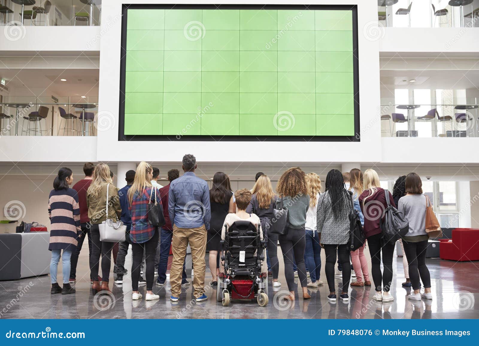 Students Looking Up at a Big Screen in University Atrium Stock Photo ...