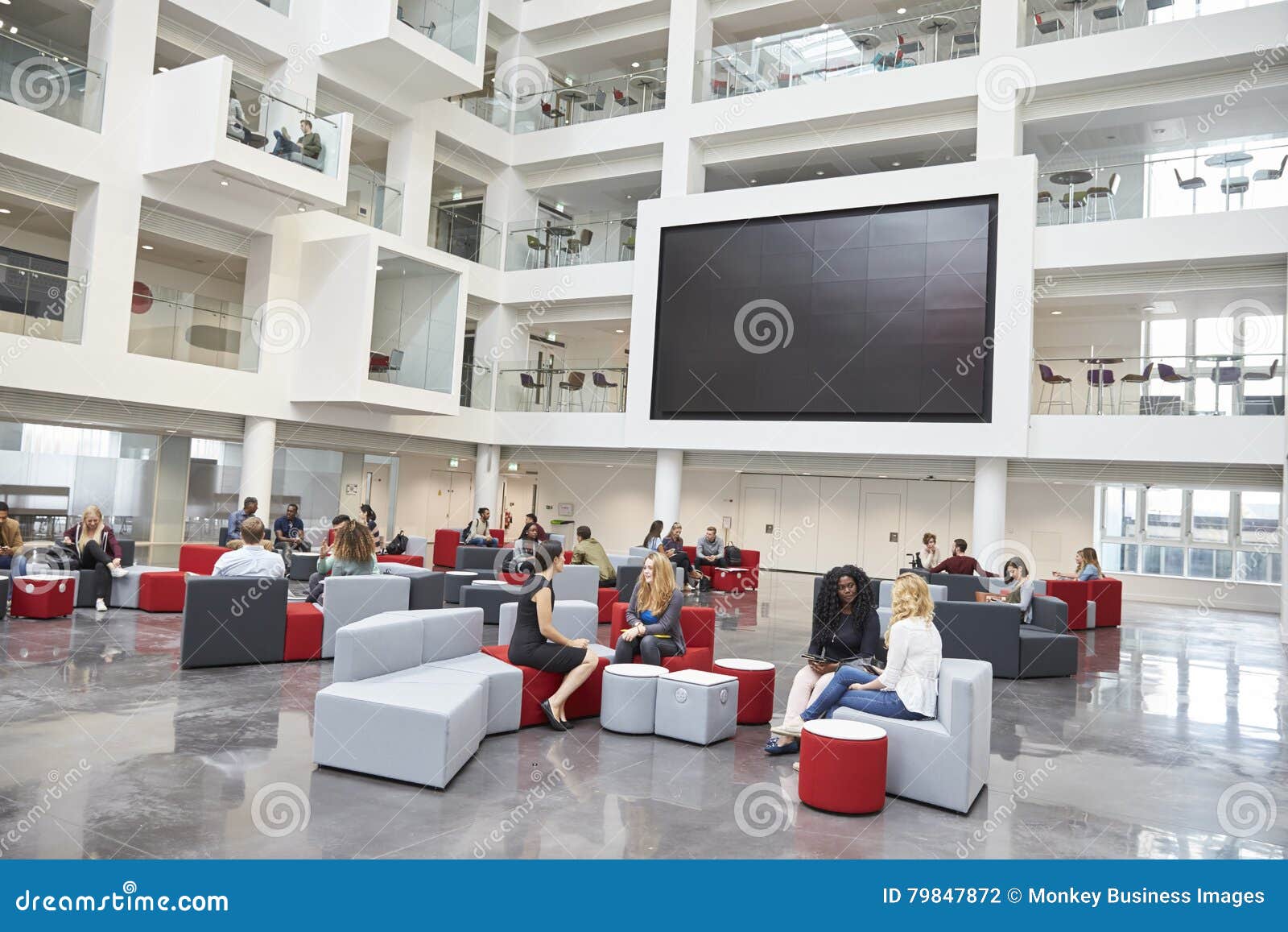 Students Meeting in Front of Screen in Atrium at University Stock Photo ...