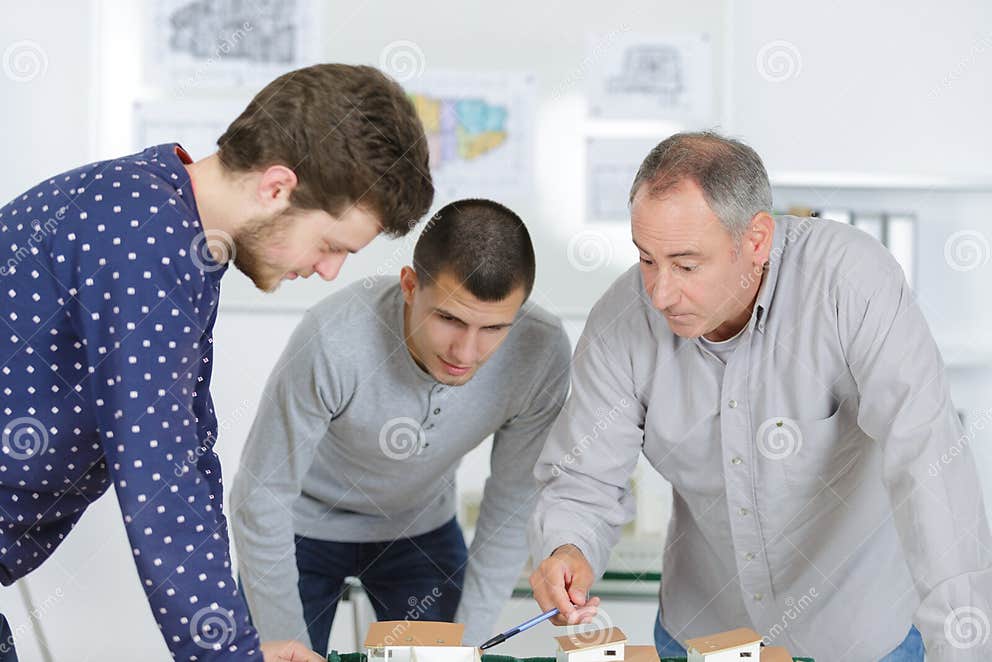 Students and Teacher Bending Over Scale Model Stock Photo - Image of ...