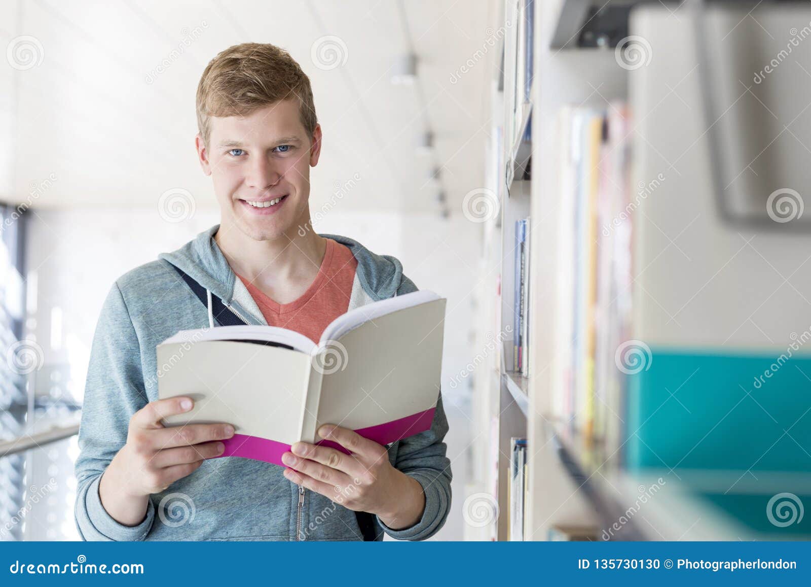 Portrait of Smiling Student Reading Book at Library in University Stock ...