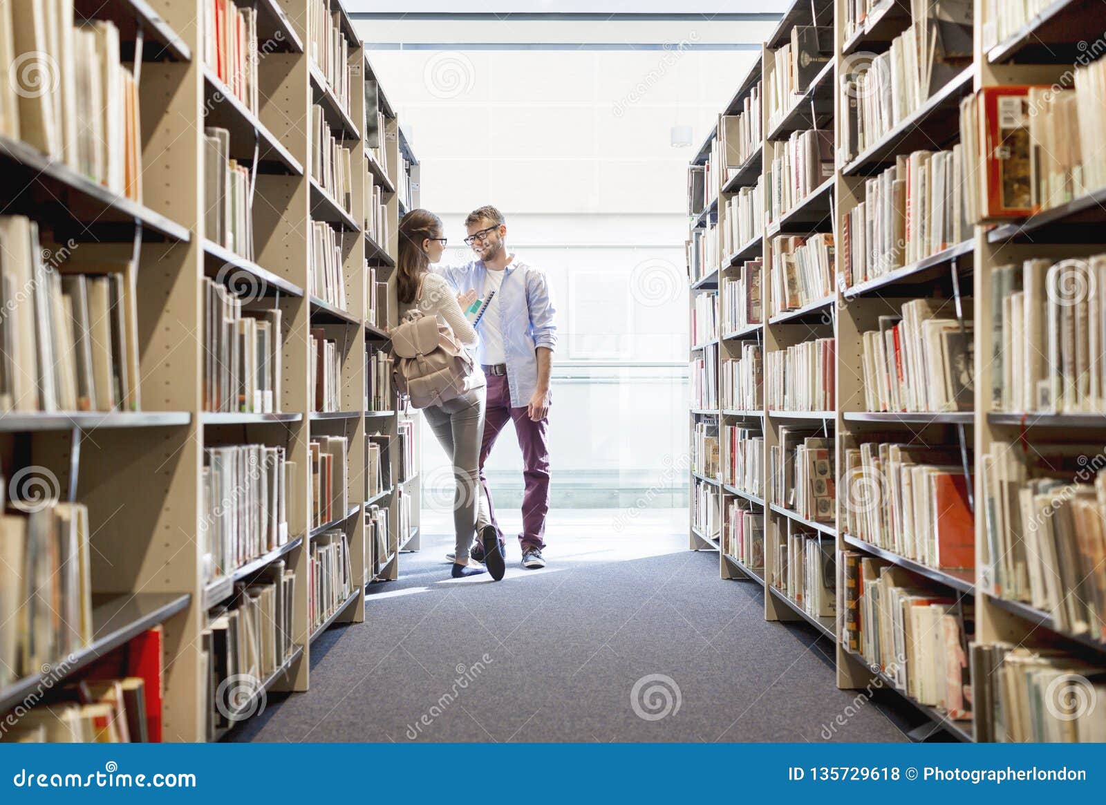 Smiling Friends Talking while Standing at University Library Stock ...