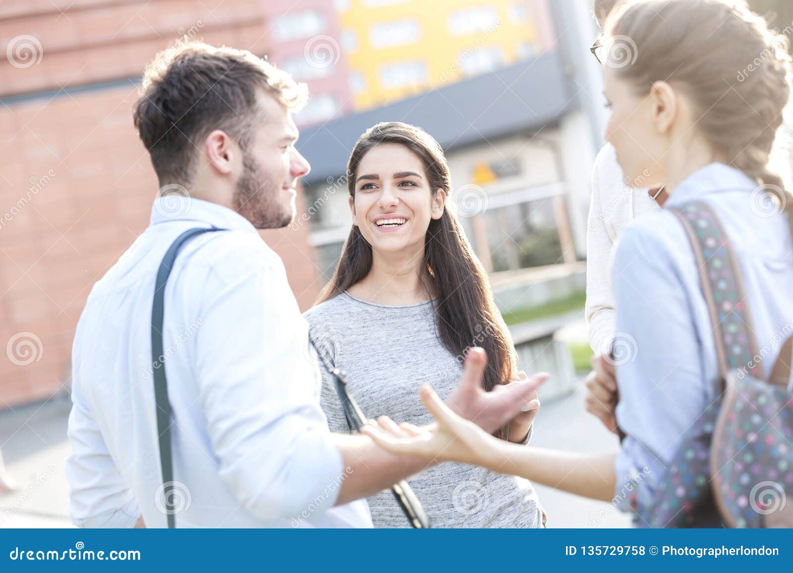 Smiling Friends Talking while Standing at University Stock Photo ...