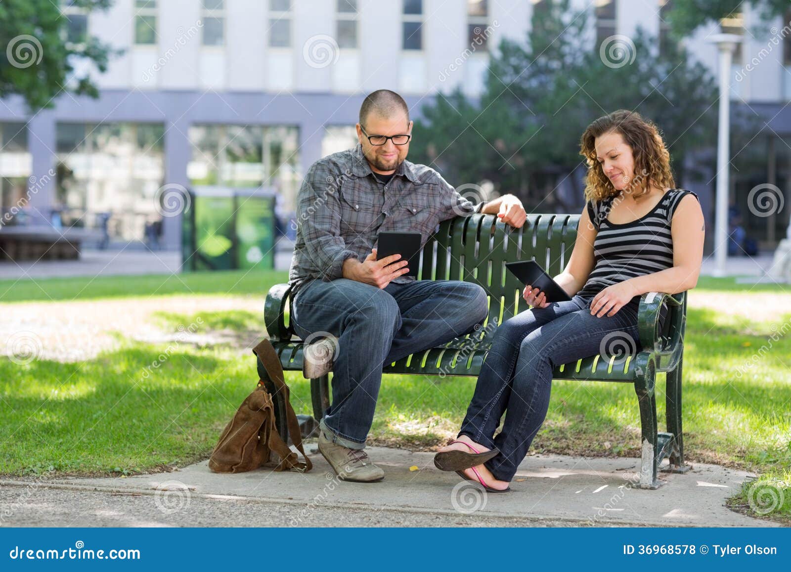Students Using Digital Tablet on Bench at Campus Stock Photo - Image of ...