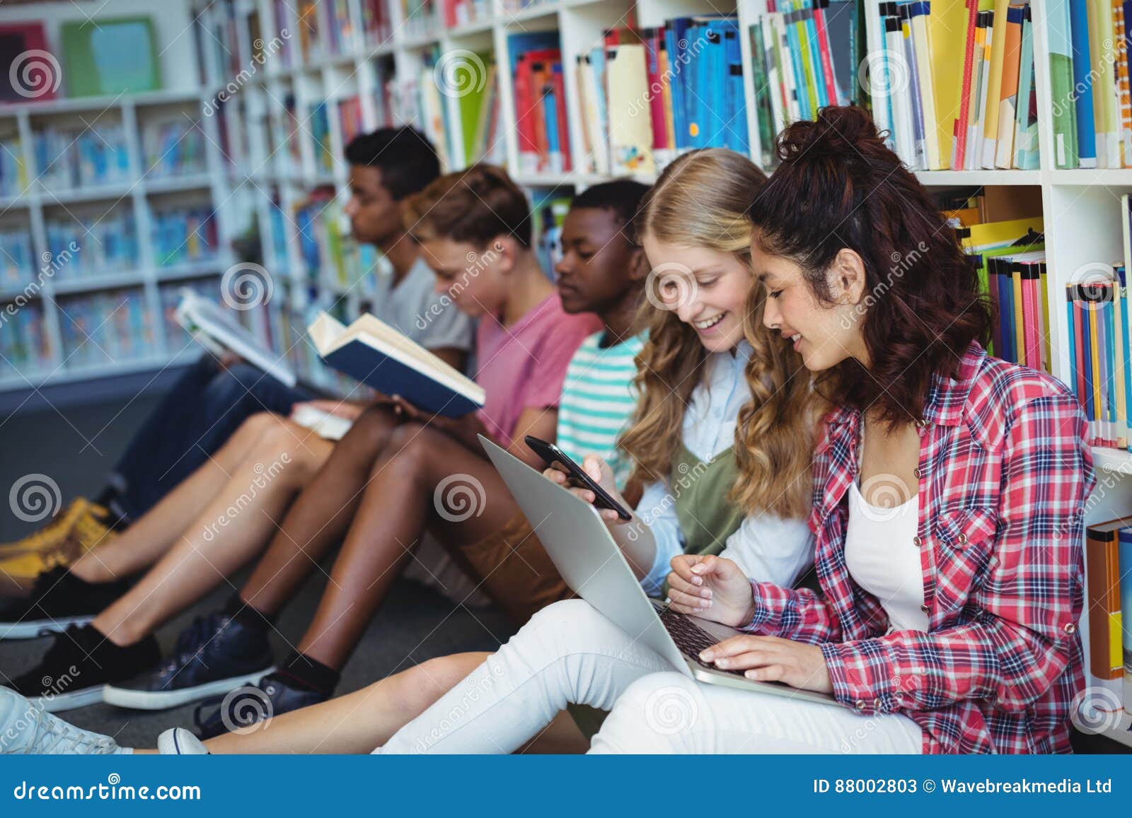 Students Using Mobile Phone and Laptop in Library Stock Image - Image ...