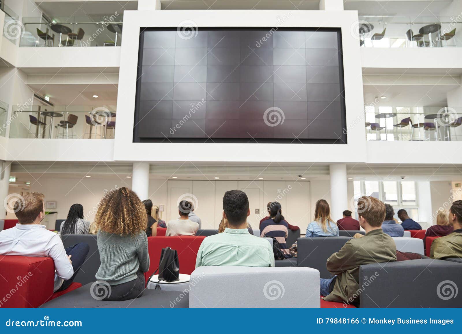 Students Watching Big Screen in University Atrium, Back View Stock ...