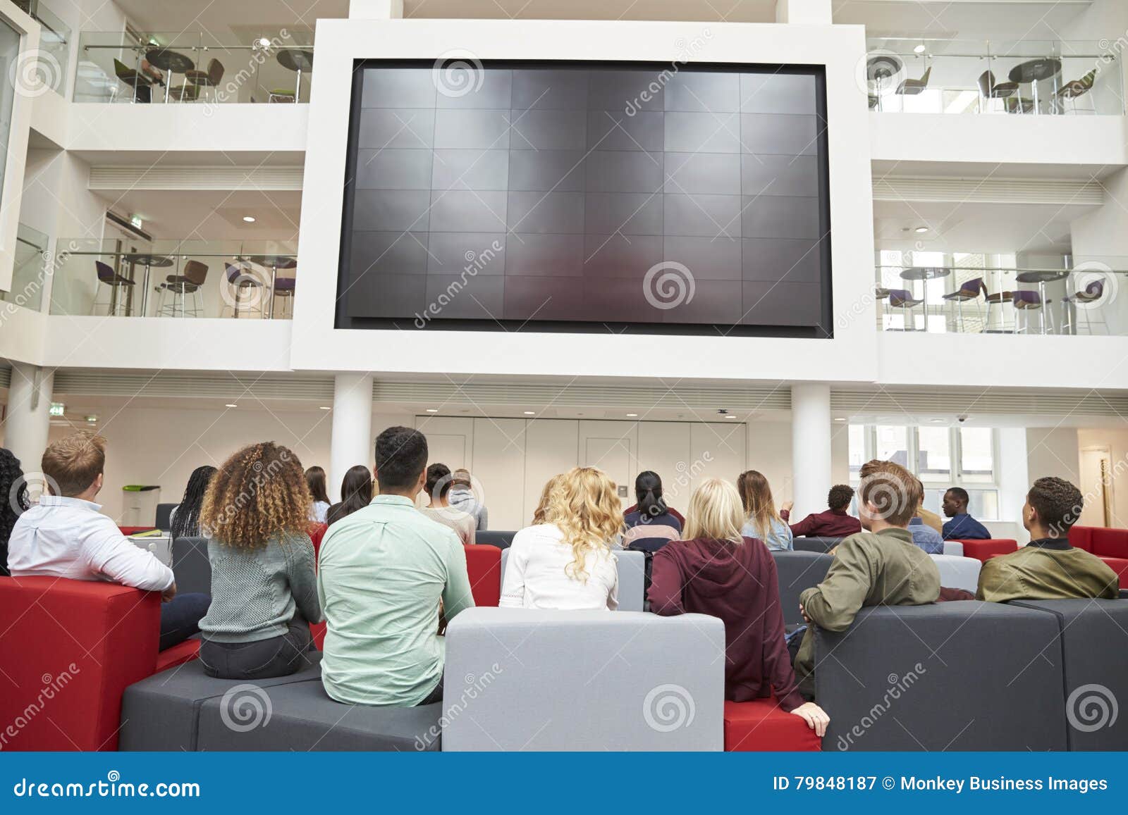 Students Watching Big Screen in University Atrium, Back View Stock ...