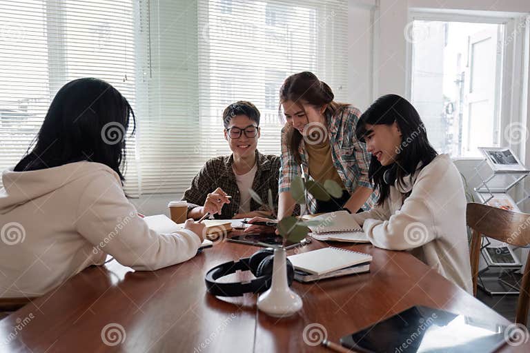 Diverse Group of Students Collaborating on Homework in a Bright Modern ...