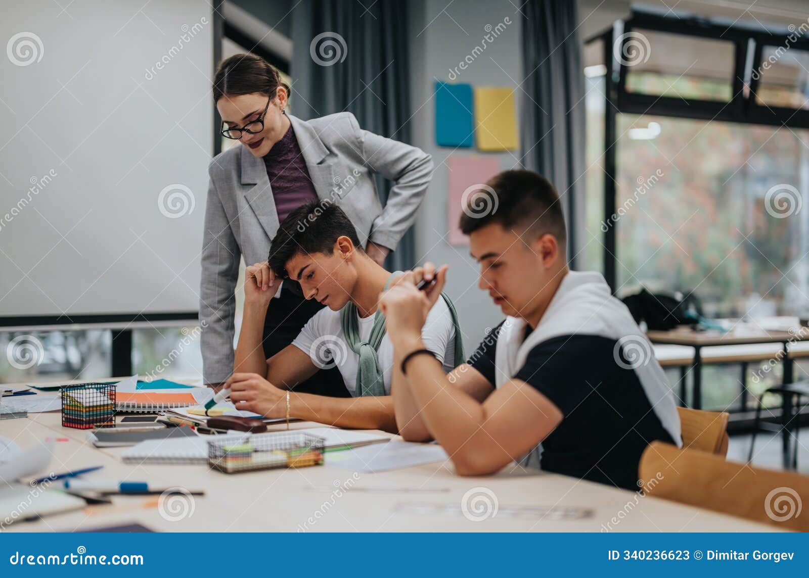Students Working Together Under Teacher Supervision in a Classroom ...