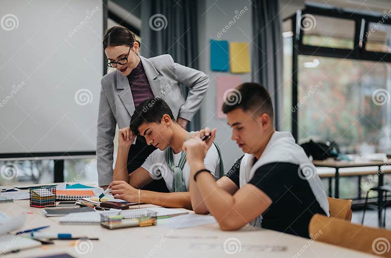 Students Working Together Under Teacher Supervision in a Classroom ...