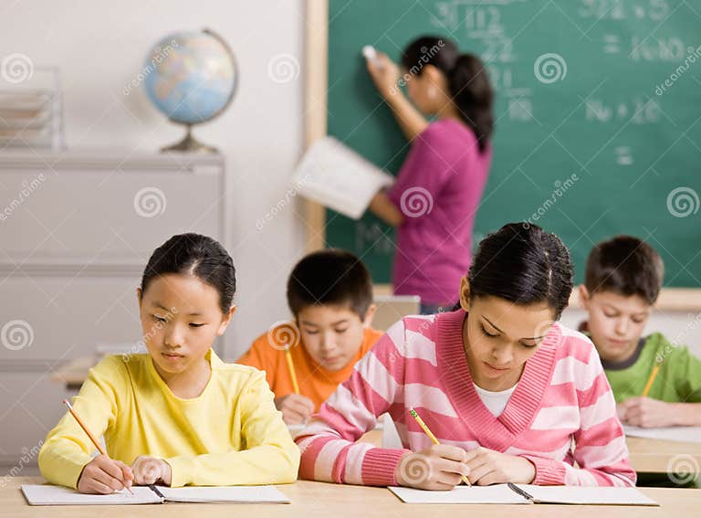 Students Writing in Notebook in School Classroom Stock Photo - Image of ...