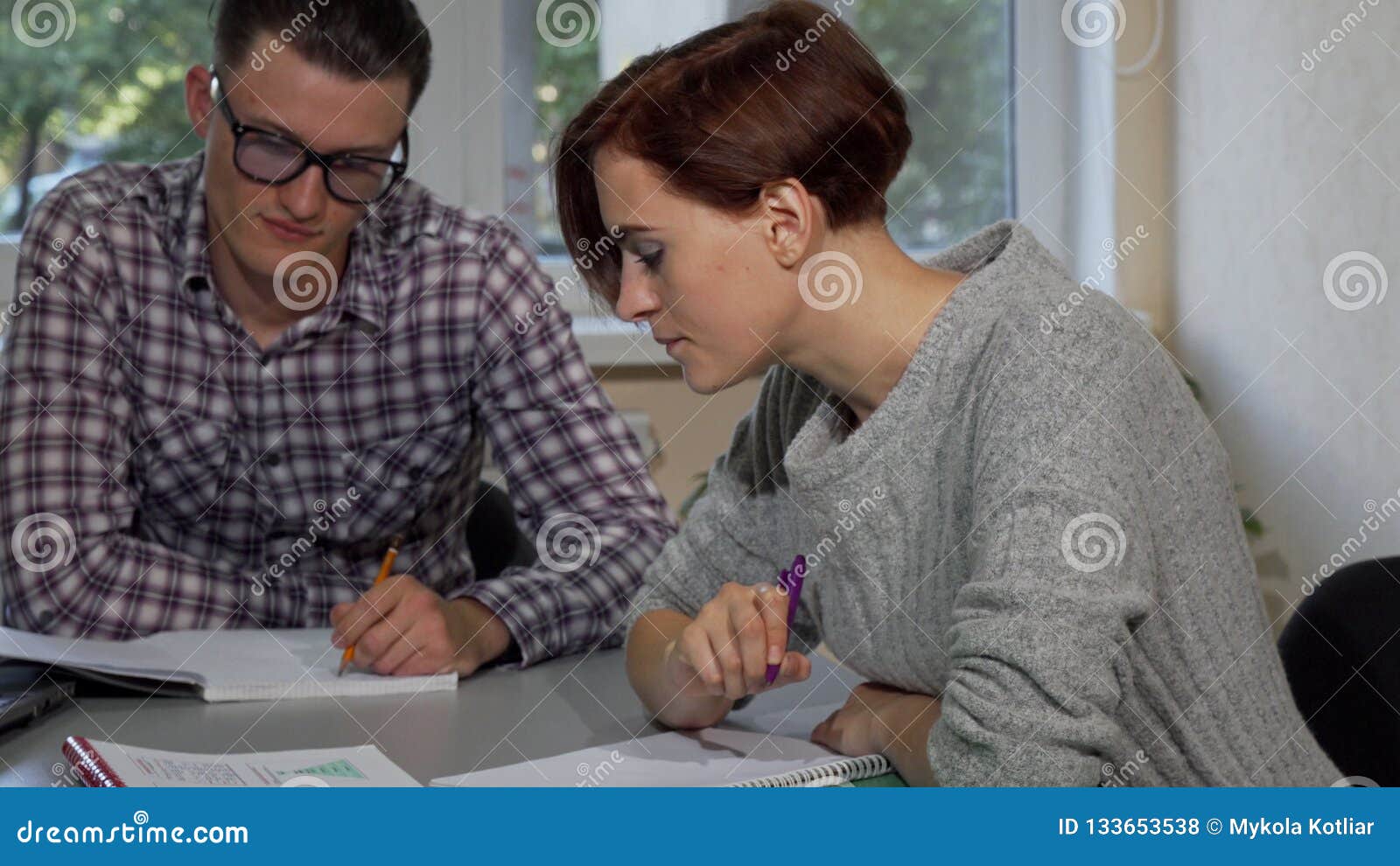 Students Writing in Their Textbooks at Class Stock Photo - Image of ...
