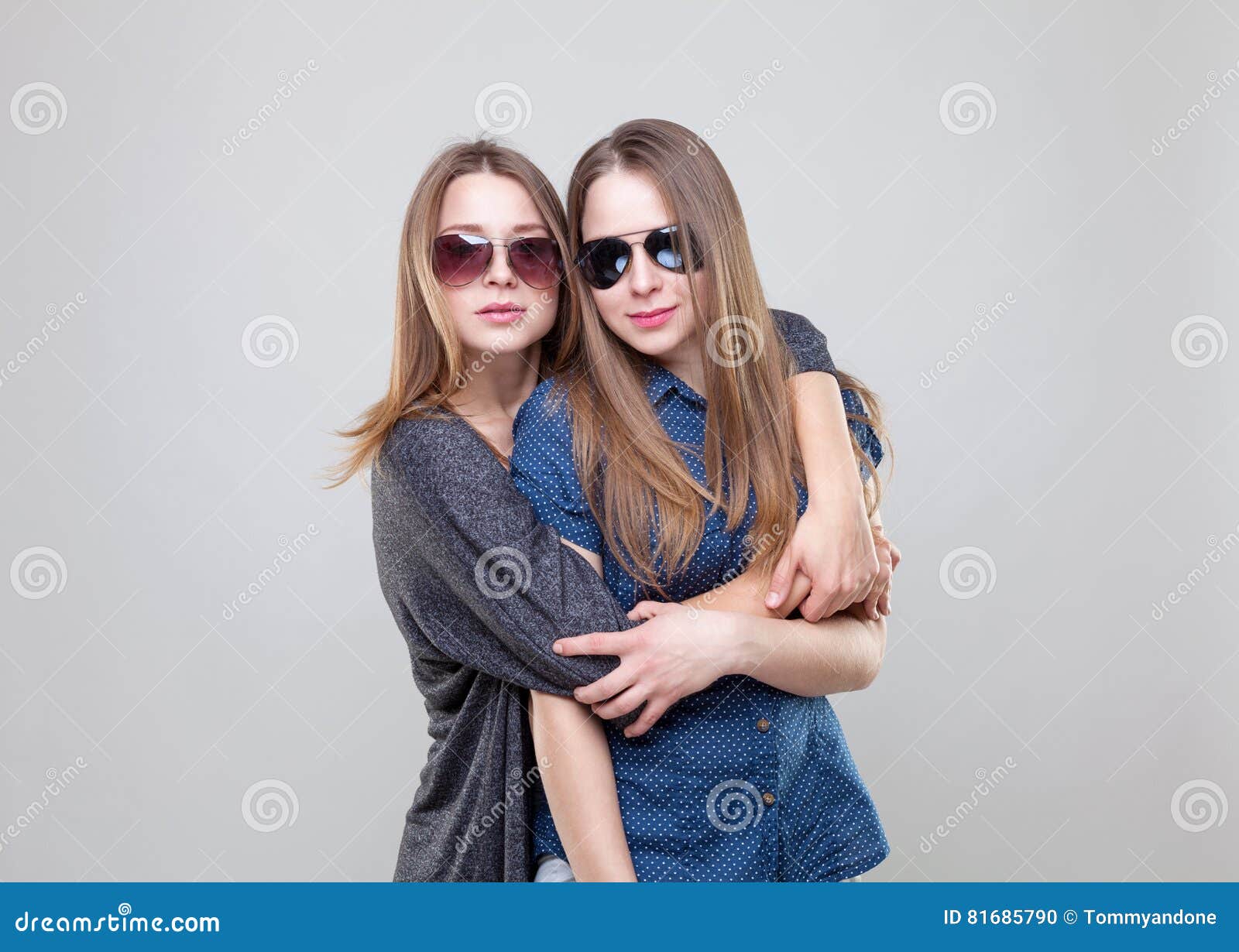 Studio Portait of Young Twin Sisters Embracing Stock Photo - Image of ...