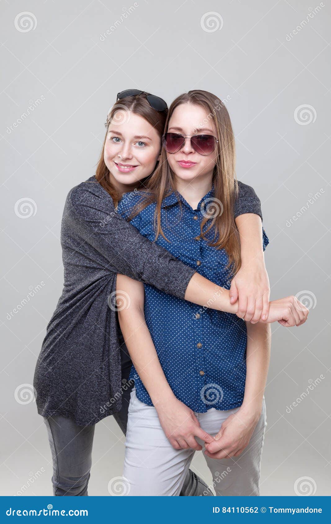 Studio Portait of Young Twin Sisters Embracing Stock Photo - Image of ...