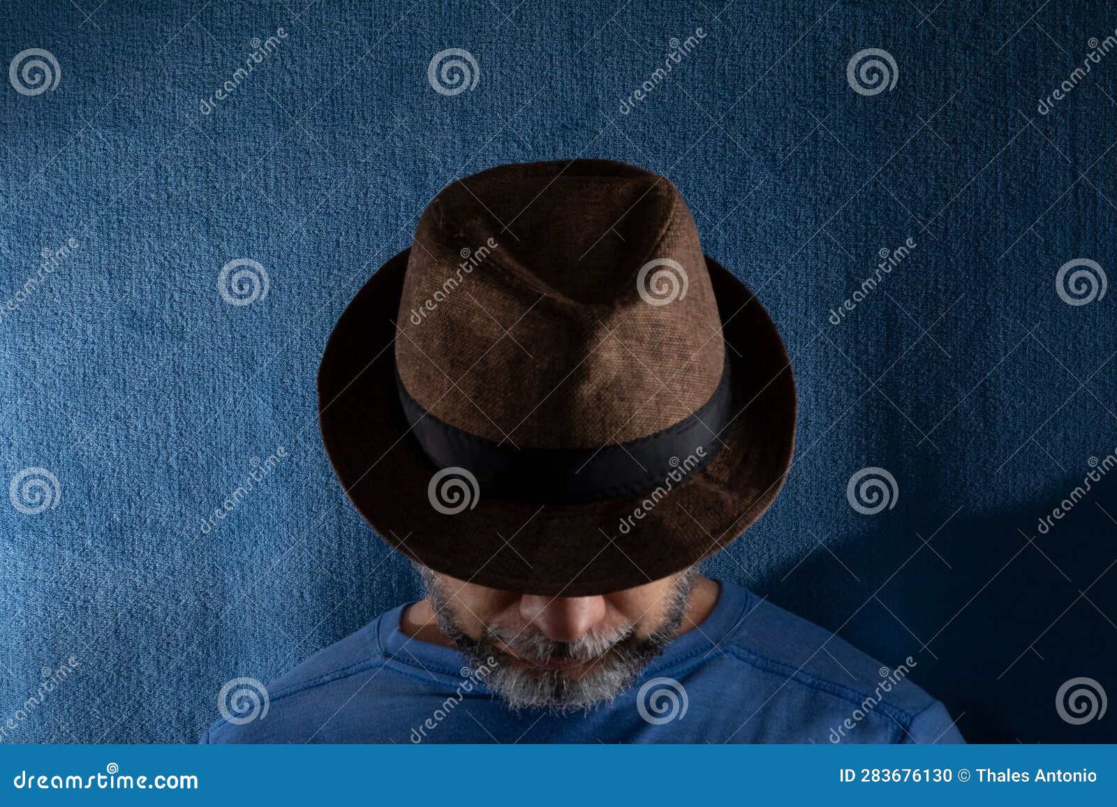 Studio Portrait of Man Wearing Hat with Head Down and Gesticulating ...