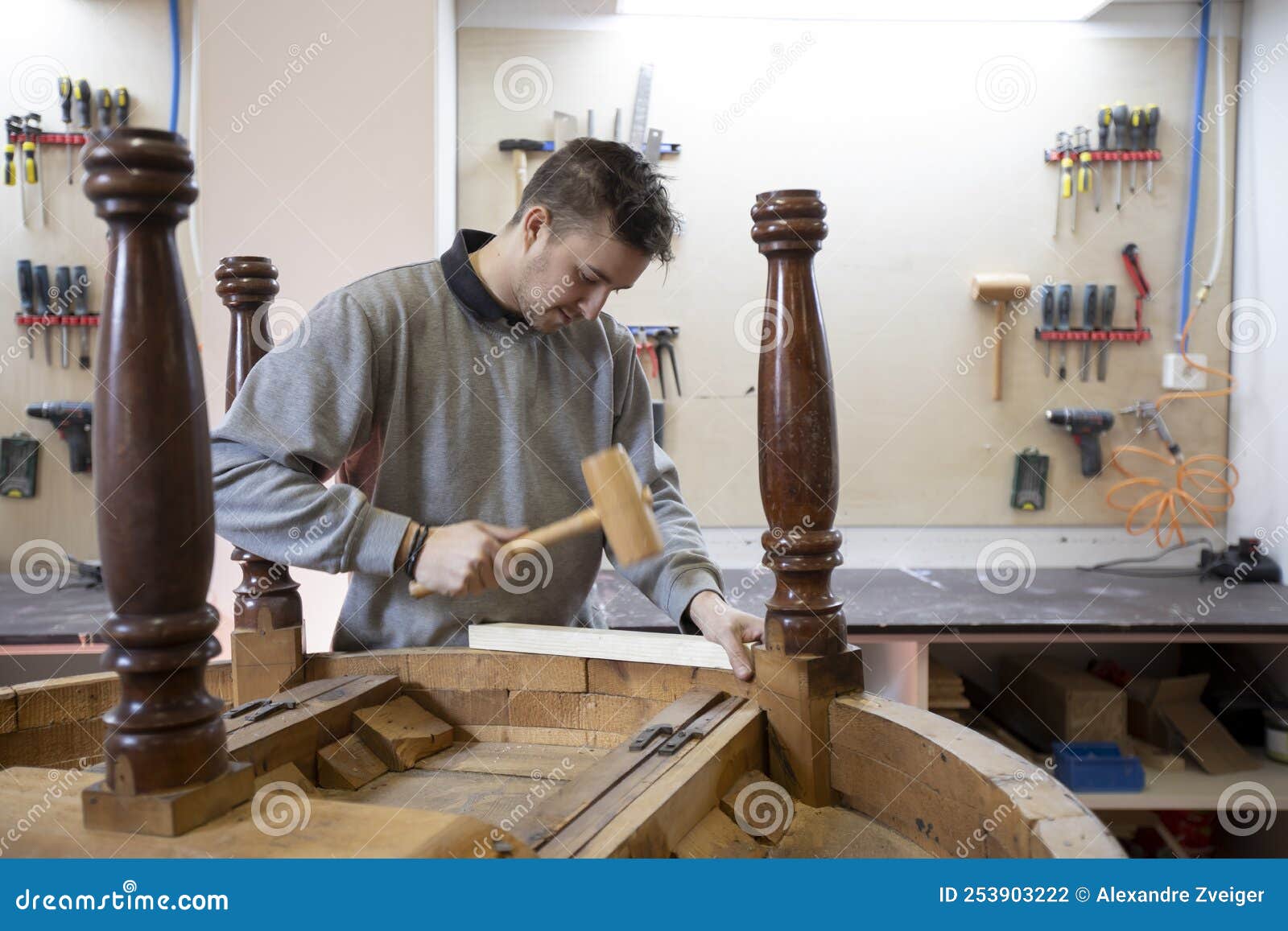 Studio Portrait of a Young Carpenter Beating with a Hammer on a Table ...