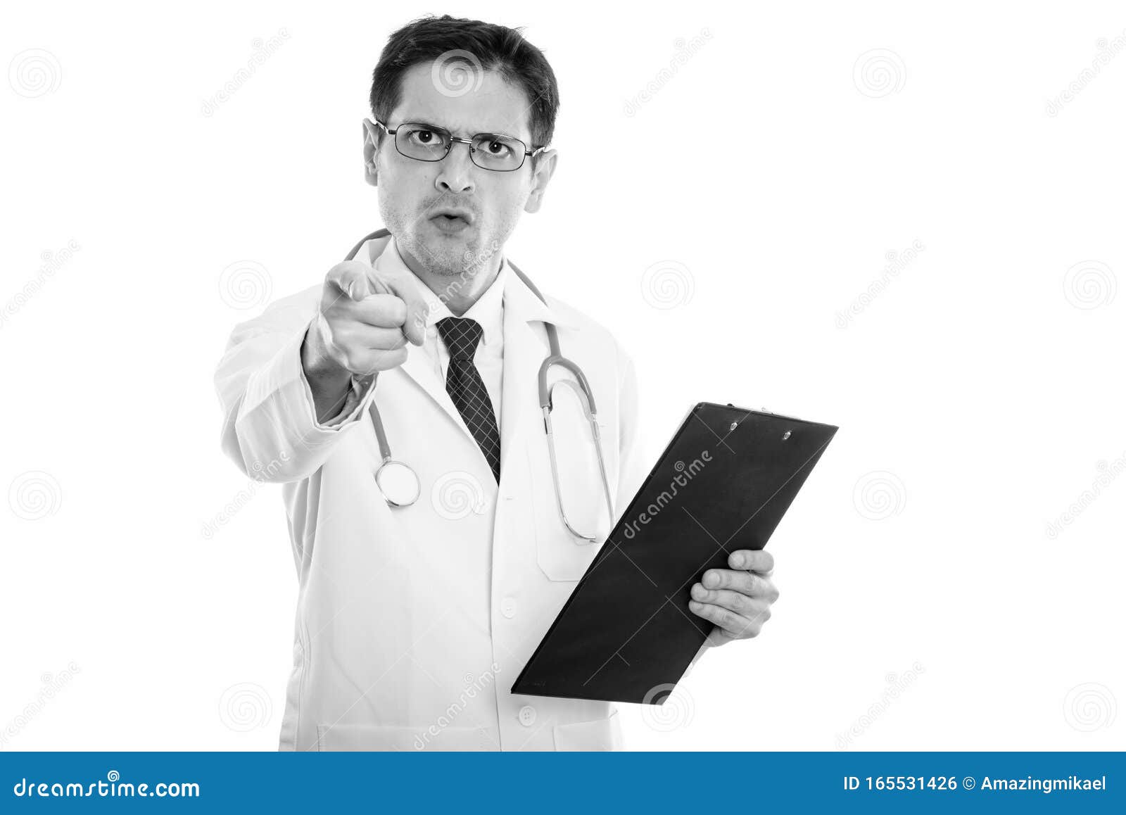 Studio Shot of Angry Young Man Doctor Holding Clipboard while Pointing ...