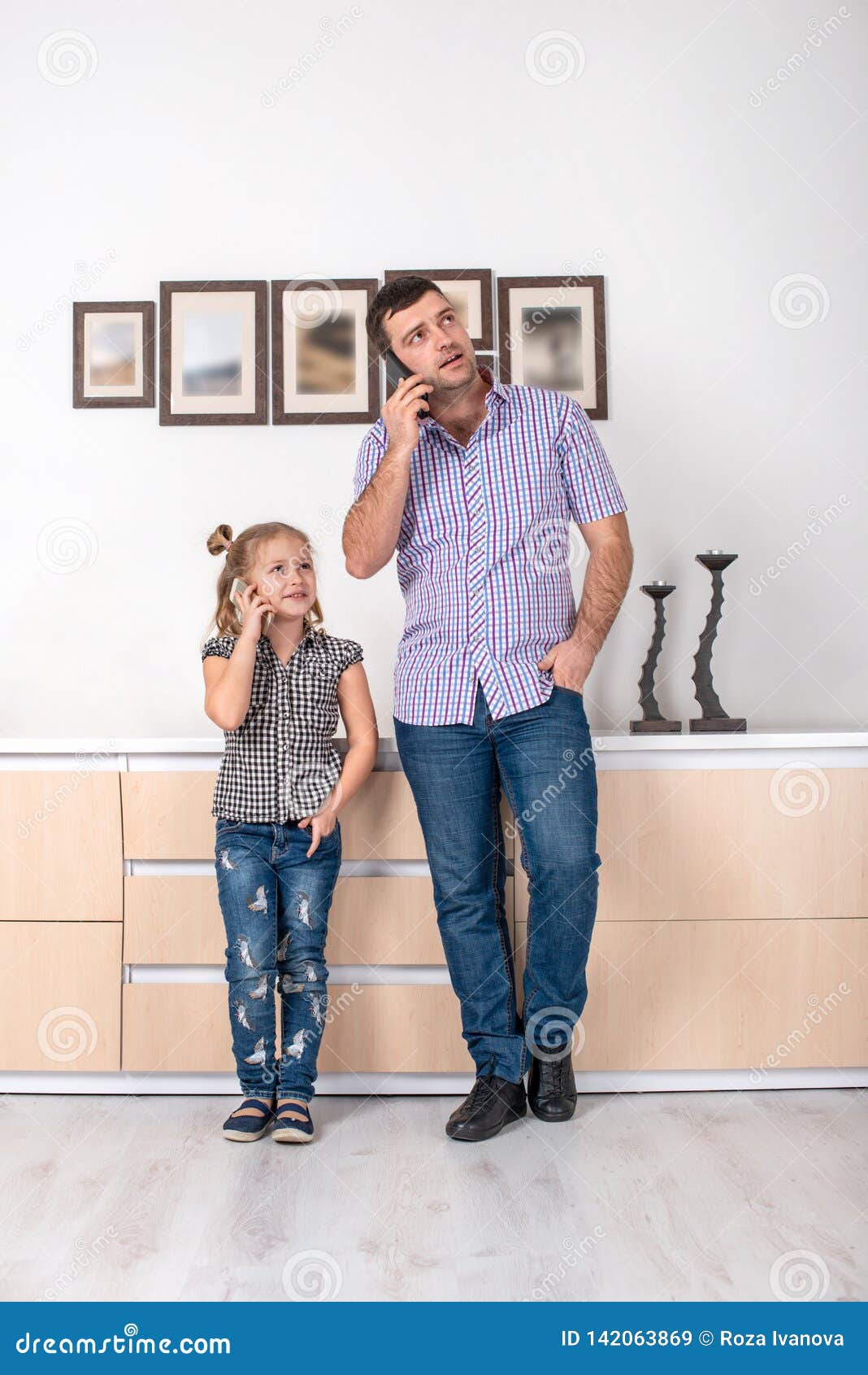 Studio Shot of a Little Girl and Her Dad Standing at Home and Talking ...