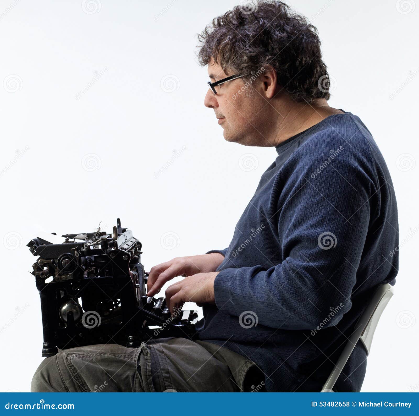 Studio Shot of a Man Typing with the Typewriter on His Lap Stock Photo ...