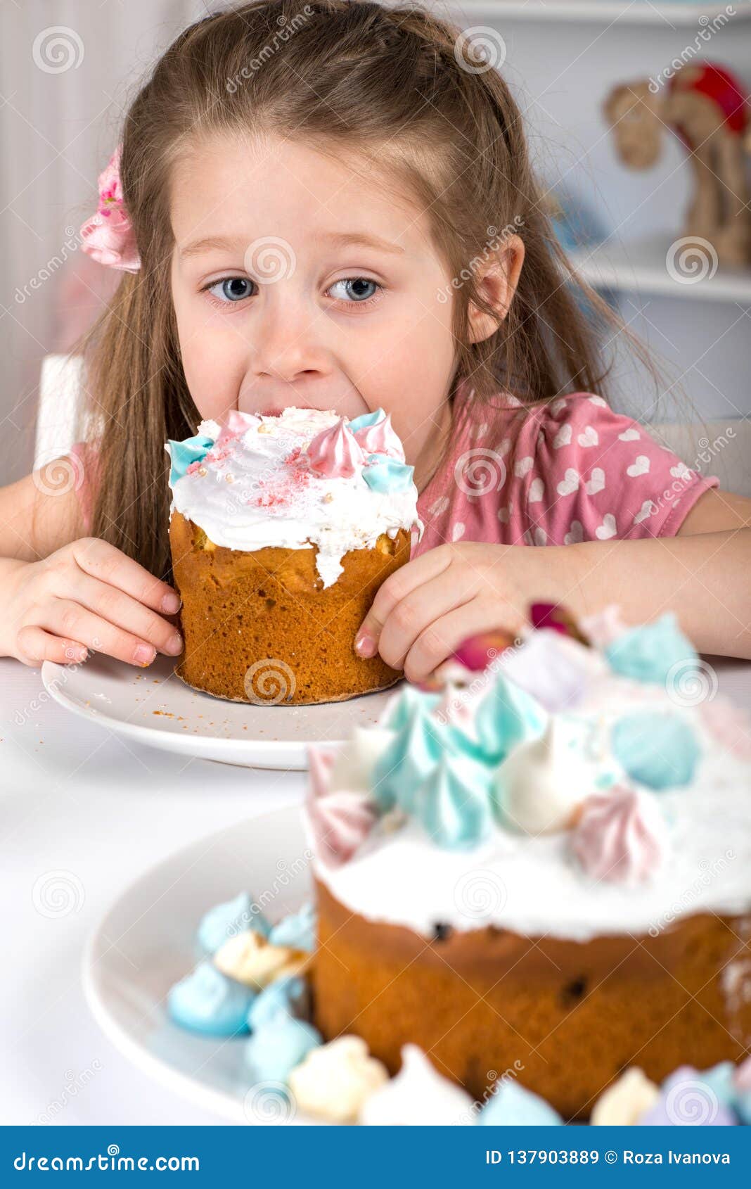 Studio Shot of Small Girl Sitting at a Table and Eating Easter Cakes ...