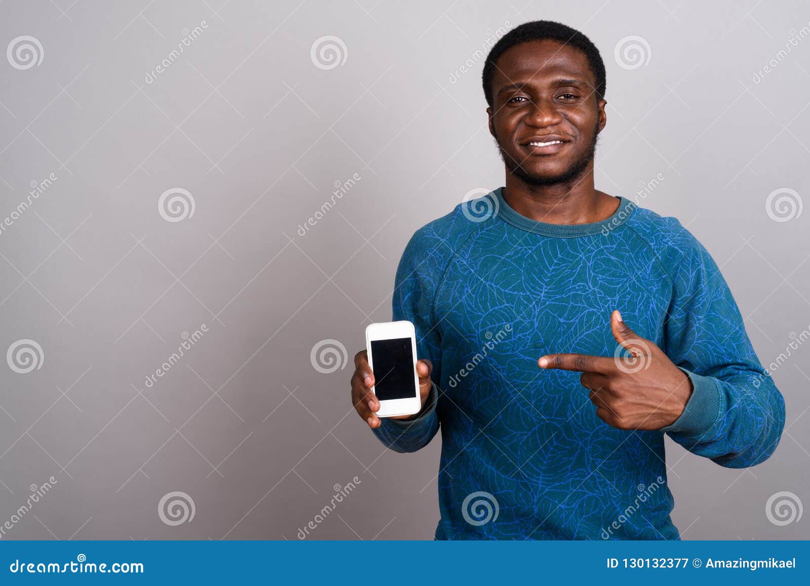 Young African Man Using Mobile Phone Against Gray Background Stock ...