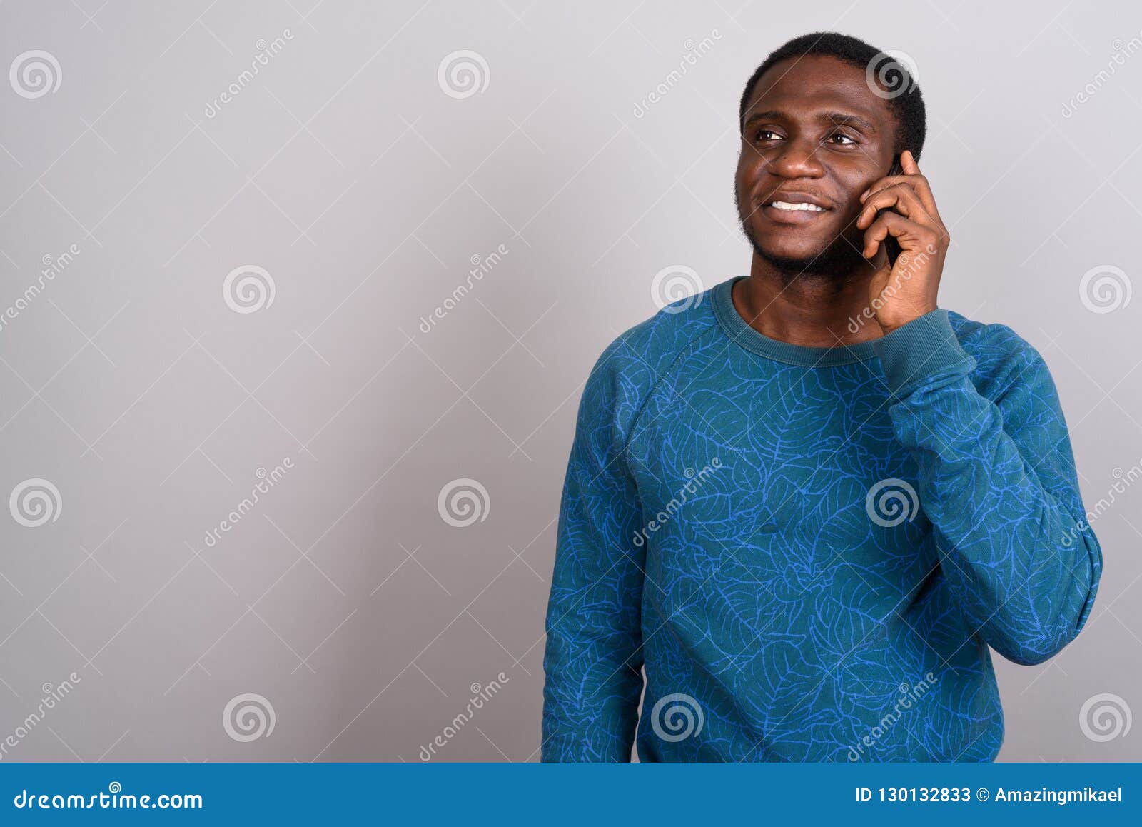 Young African Man Using Mobile Phone Against Gray Background Stock ...