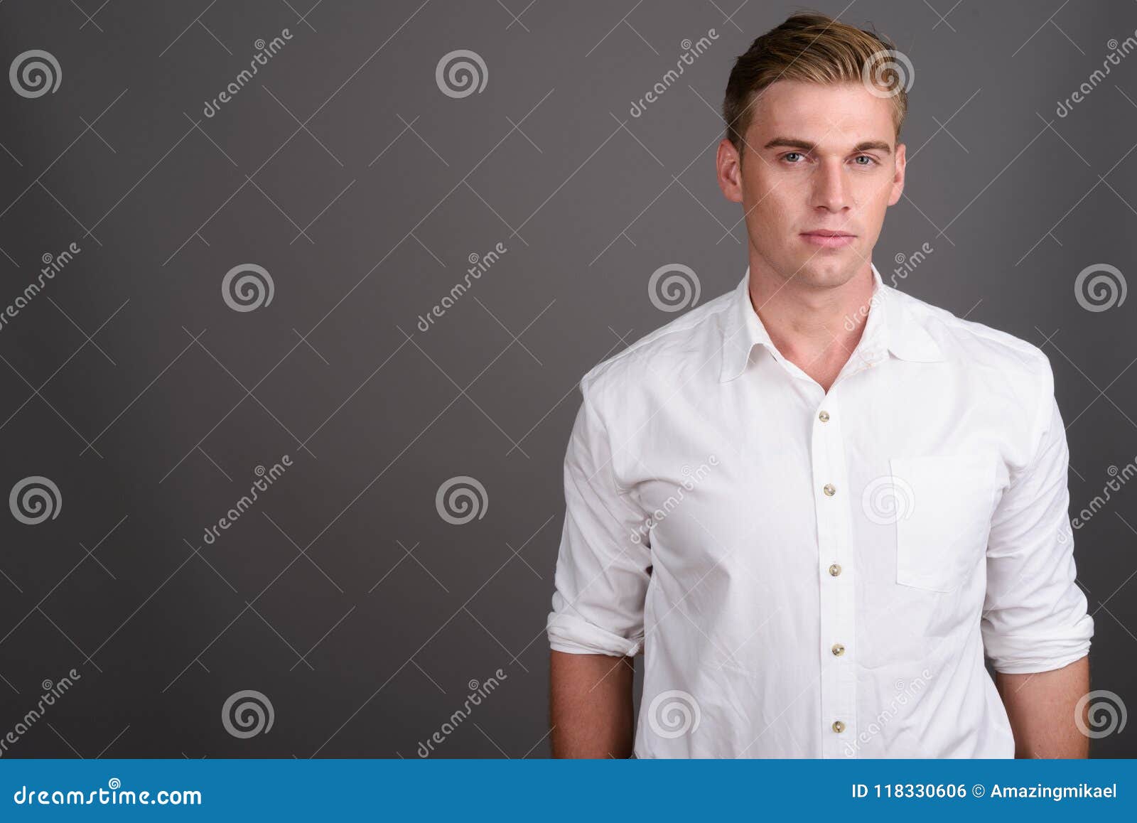 Young Handsome Businessman With Blond Hair Against Gray Backgrou Stock