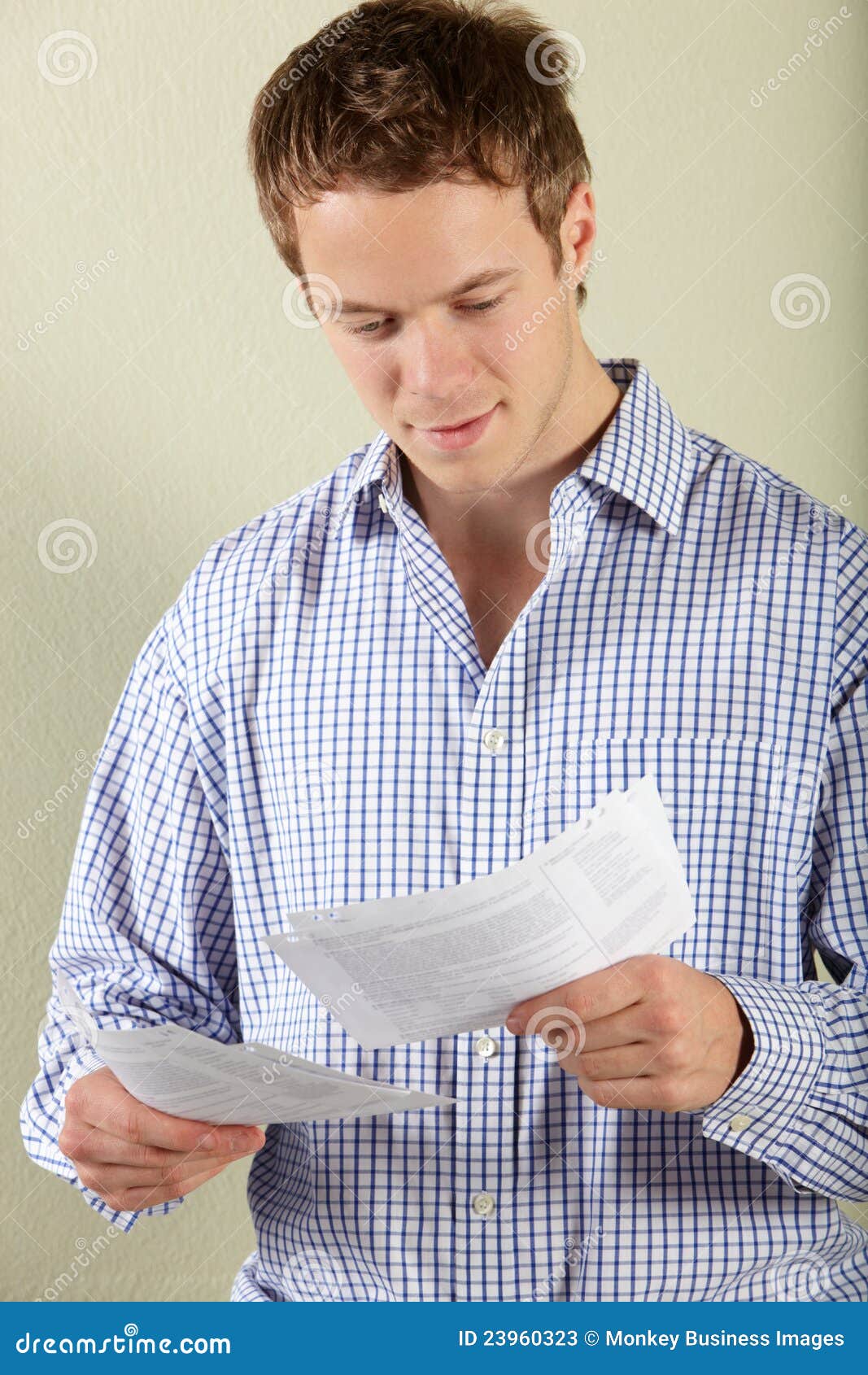 Studio Shot of Young Man Looking at Bills Stock Image - Image of ...