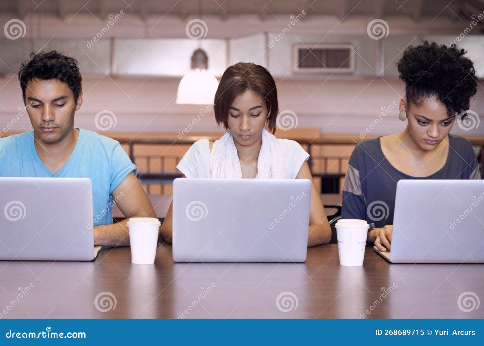Study Group Dynamics. Studio Shot of Three Students Sitting at a Desk ...