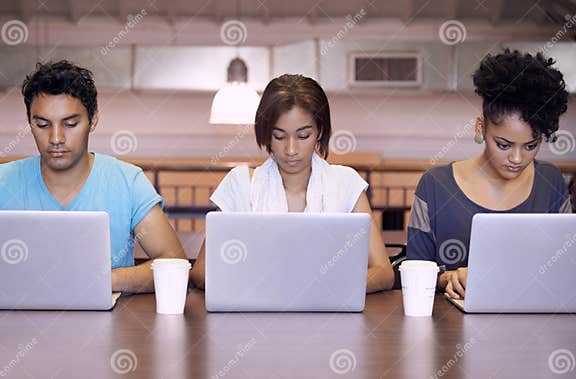 Study Group Dynamics. Studio Shot of Three Students Sitting at a Desk ...