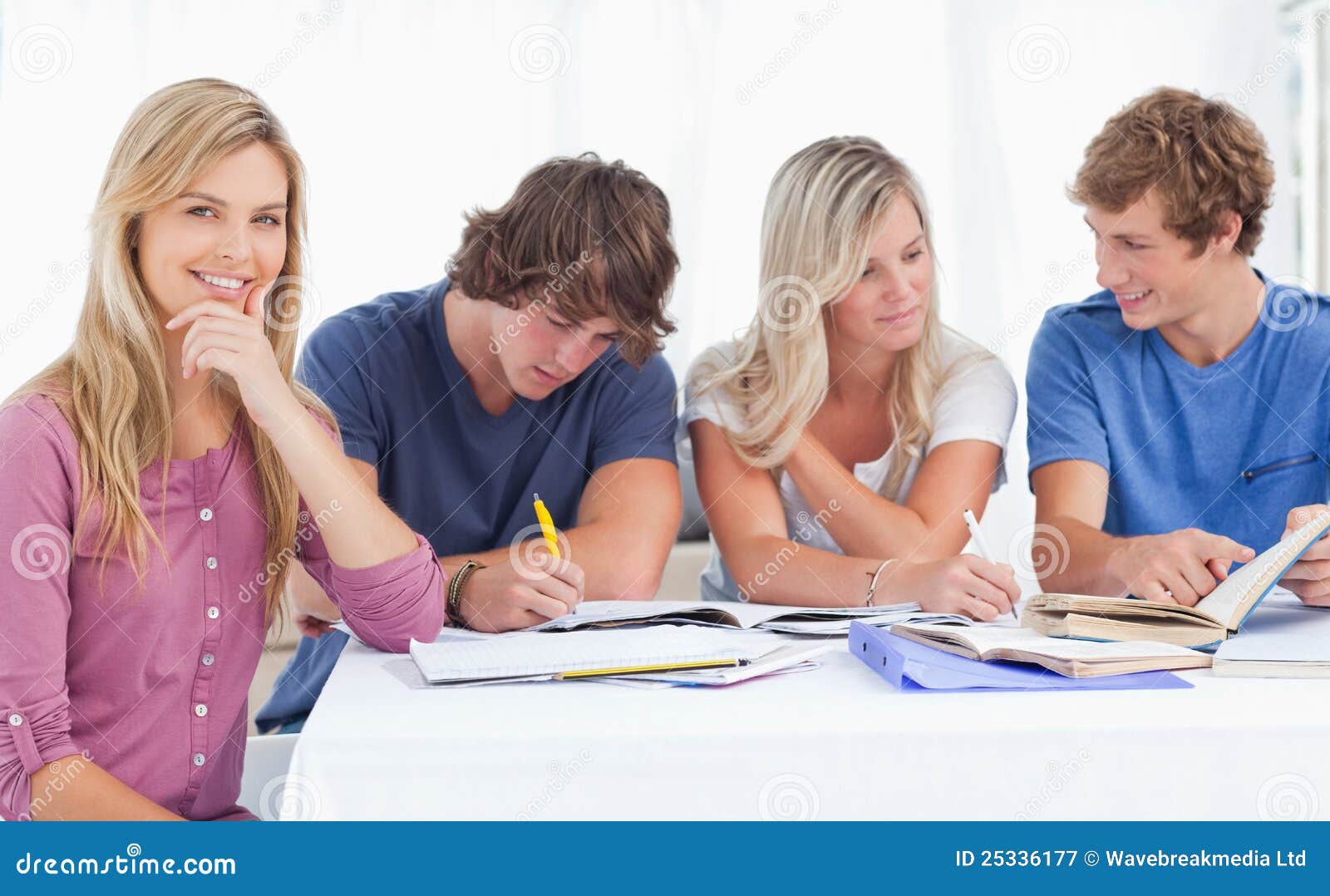 A Study Group Working Hard As One Girl Smiles Stock Image - Image of ...