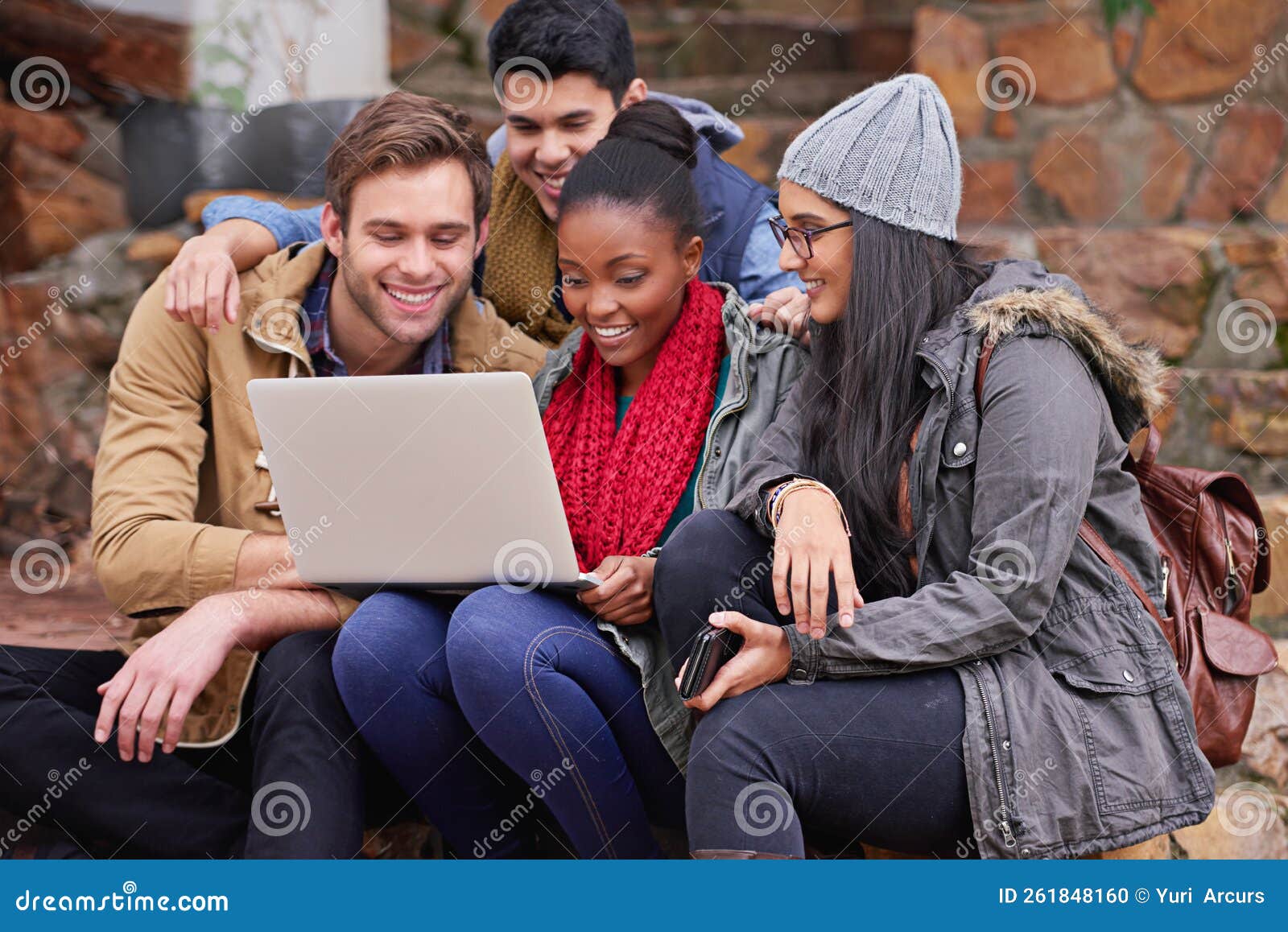 Studying As a Group. University Students Using a Laptop while Sitting ...