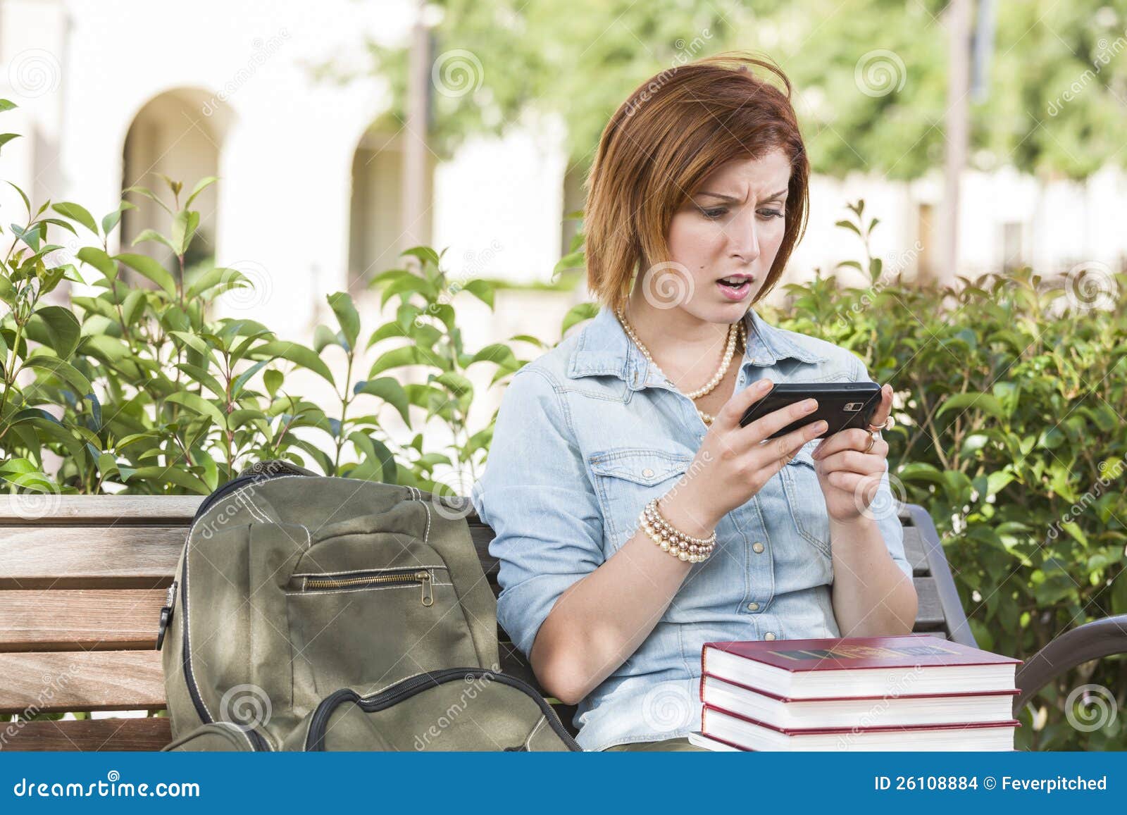 Stunned Young Female Student Outside Texting on Cell Phone Stock Photo ...