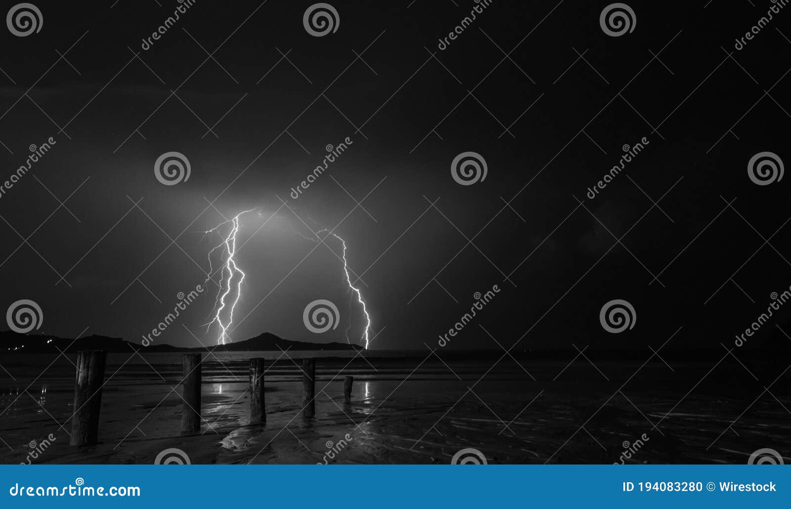 Stunning Grayscale Shot of a Distant Lightning Strike from a Pier Stock ...