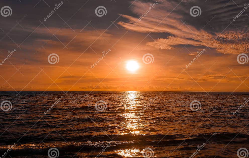 Stunning View of an Ocean at Sunset, with an Array of Vibrant Clouds in the Sky Stock Photo ...