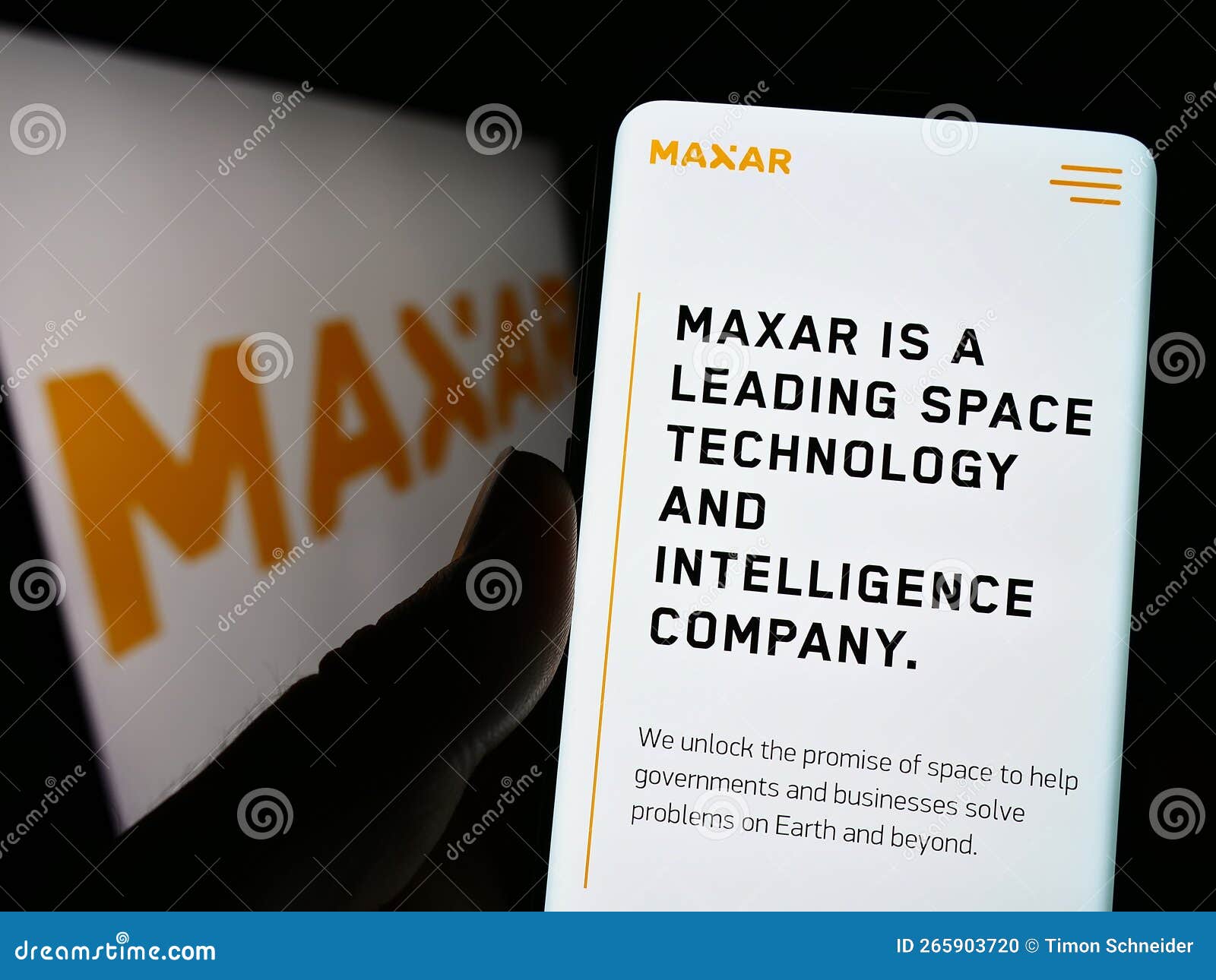 Person Holding Cellphone with Webpage of US Space Company Maxar ...