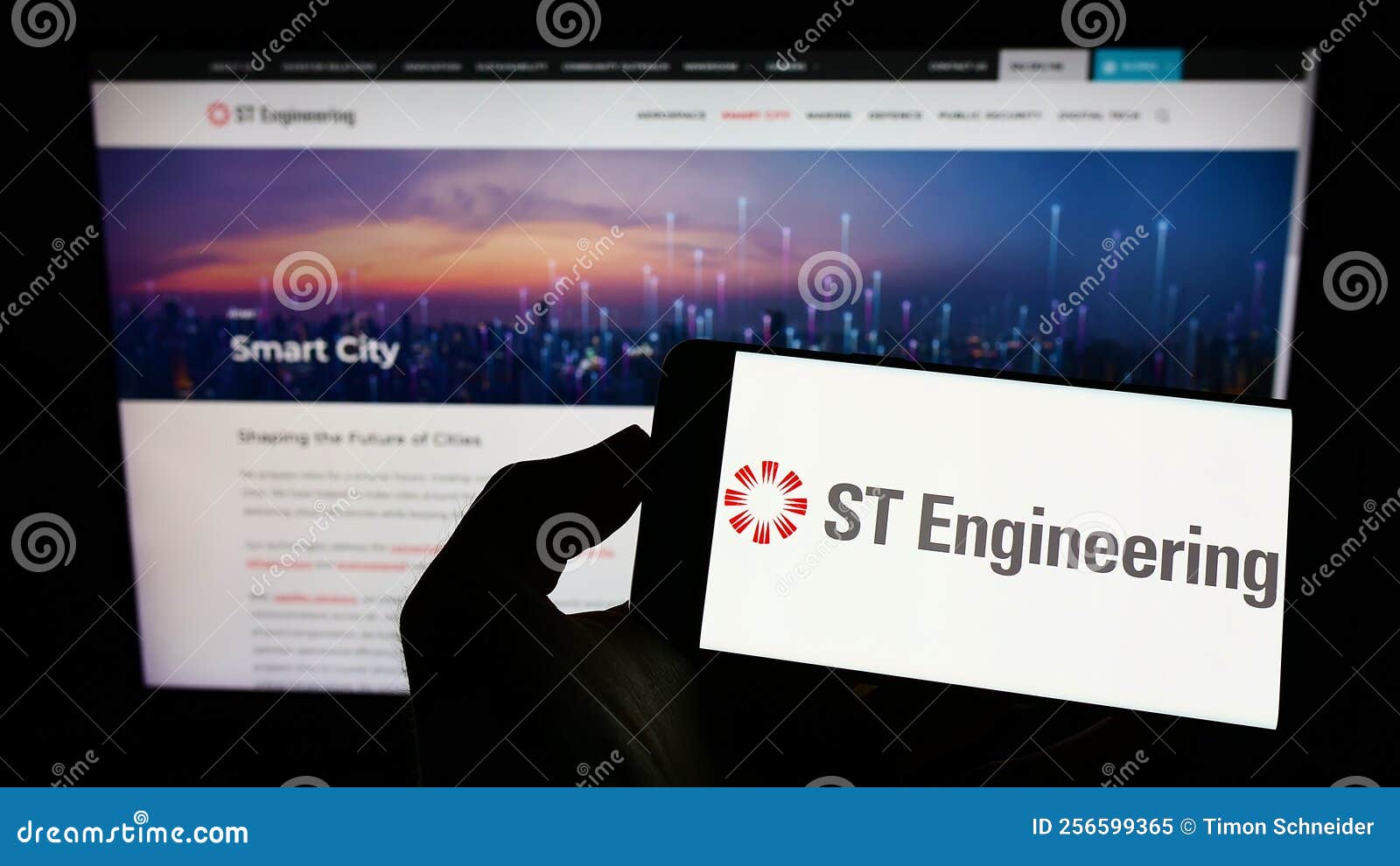 Person Holding Mobile Phone with Logo of Singapore Technologies ...