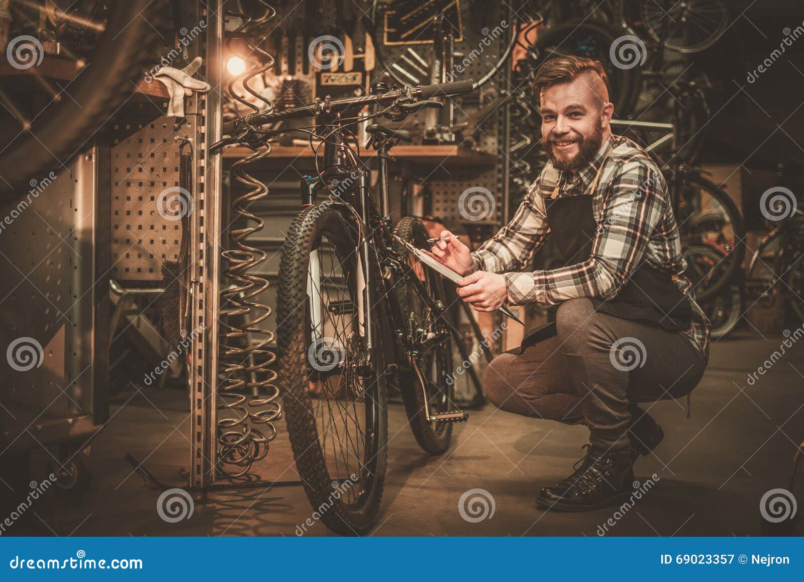 Stylish Bicycle Mechanic Making Notes in Clipboard in His Workshop ...