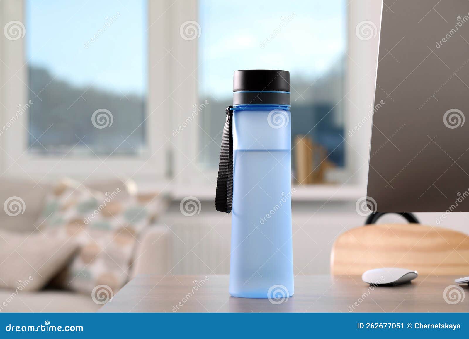 Stylish Bottle of Water and Computer on Table at Workplace in Office ...
